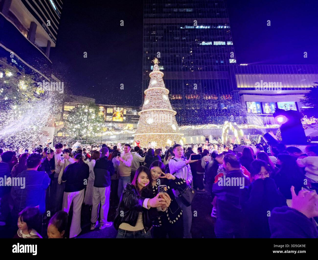 CHONGQING, CHINA - NOVEMBER 15, 2025 - Tourists play around a lit 21 ...