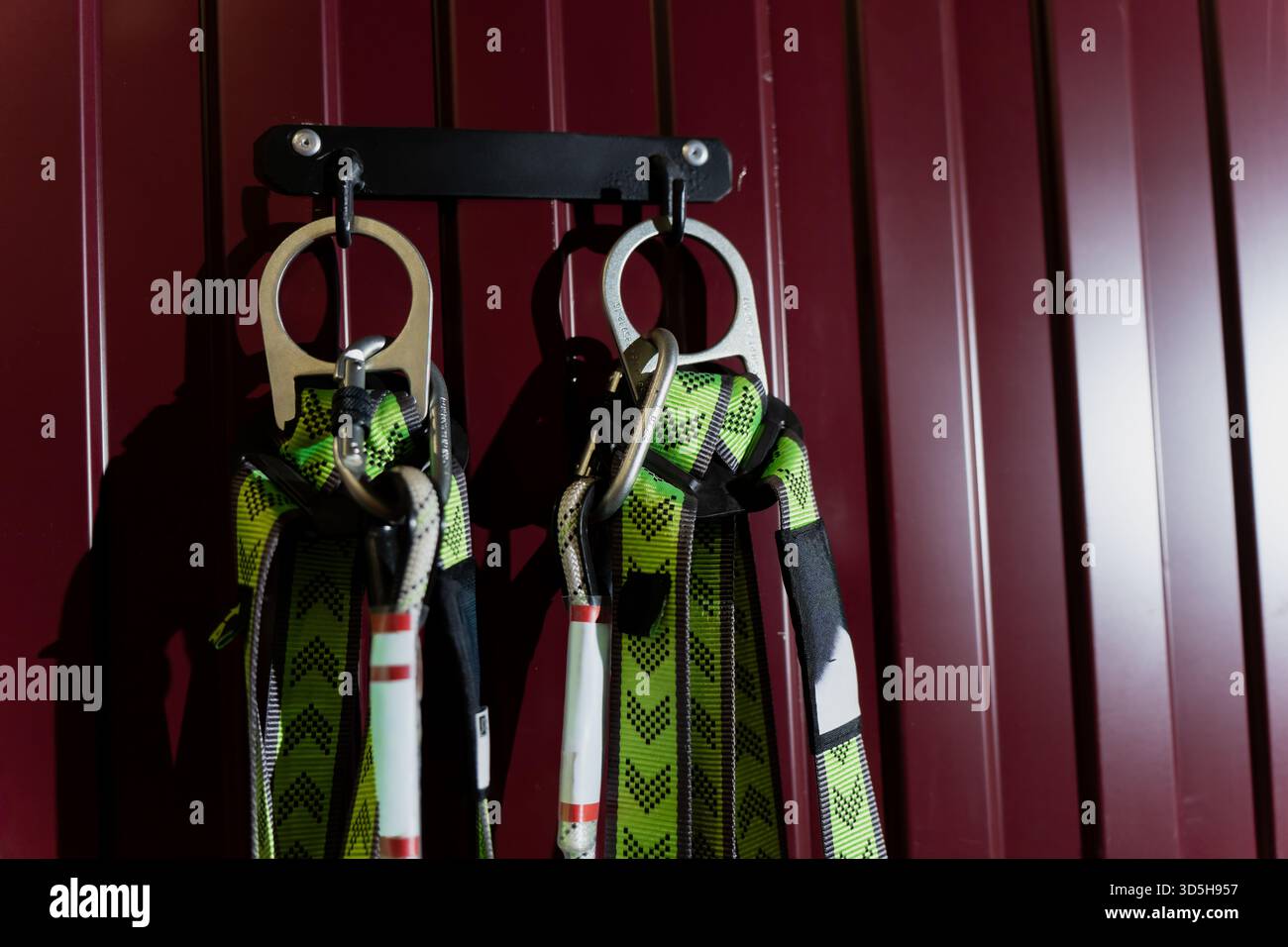 Twin fall protection lanyards with metallic anchoring hardware stored ...