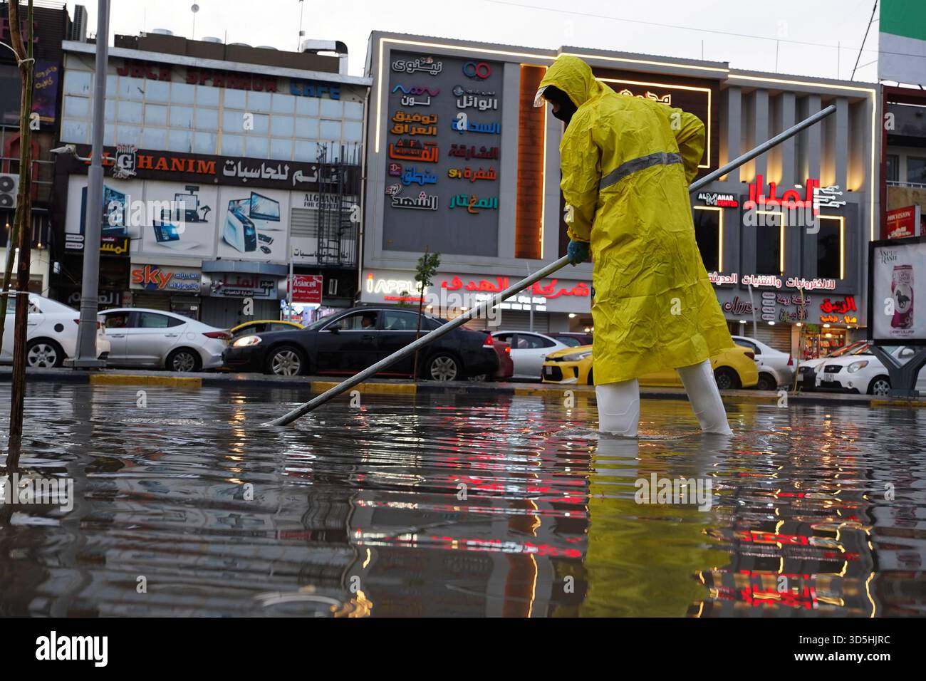 16 November 2025, Iraq, Mosul: An Iraqi serviceman cleans a flooded ...