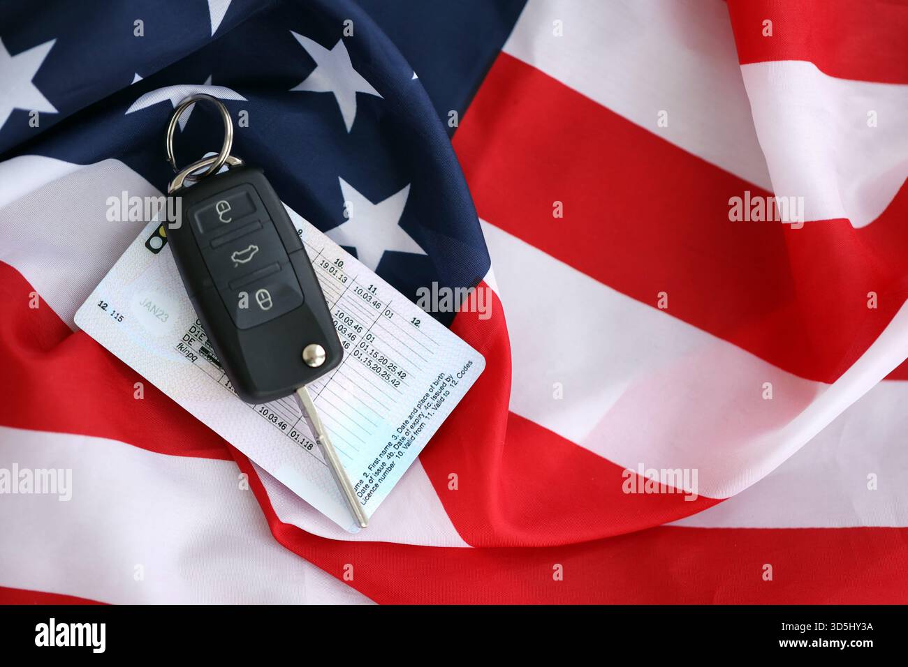 Ignition keys with remote control buttons and driver license card on ...