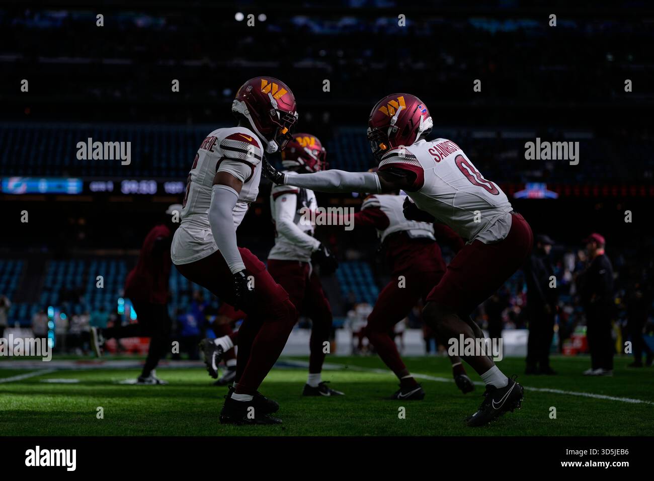 Washington Commanders cornerback Mike Sainristil (0), right, warms-up ...