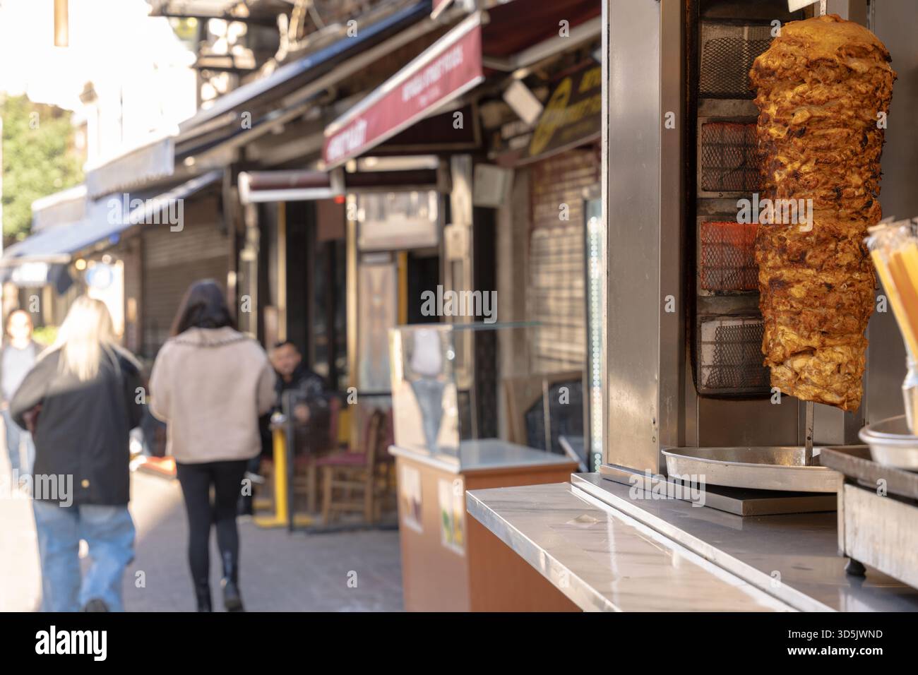 16 November 2025, Turkey, Istanbul: People walk past a kebab store in ...