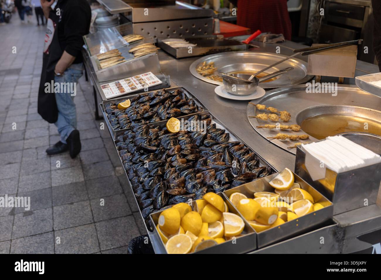 16 November 2025, Turkey, Istanbul: A vendor sells mussels, known ...