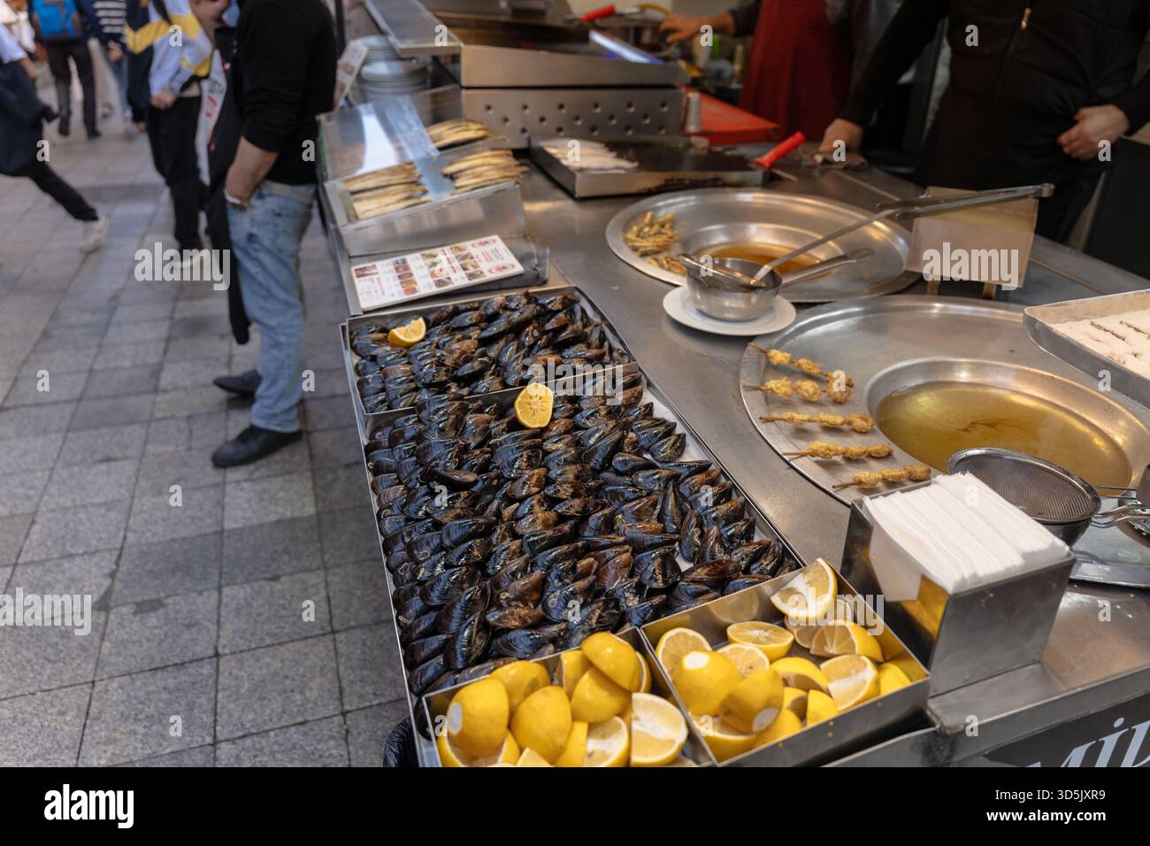 16 November 2025, Turkey, Istanbul: A vendor sells mussels, known ...