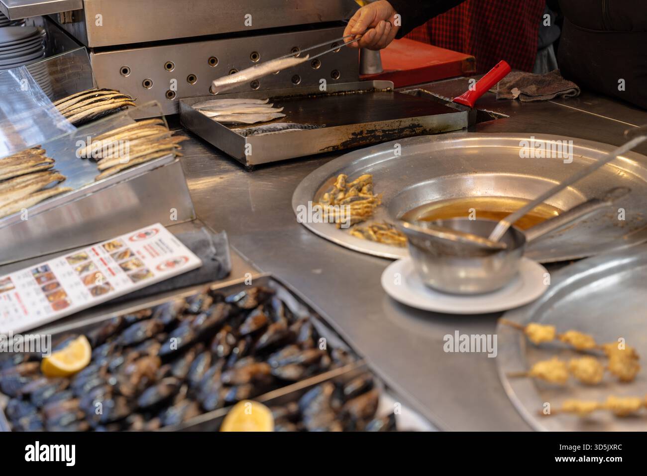 16 November 2025, Turkey, Istanbul: A vendor sells mussels, known ...