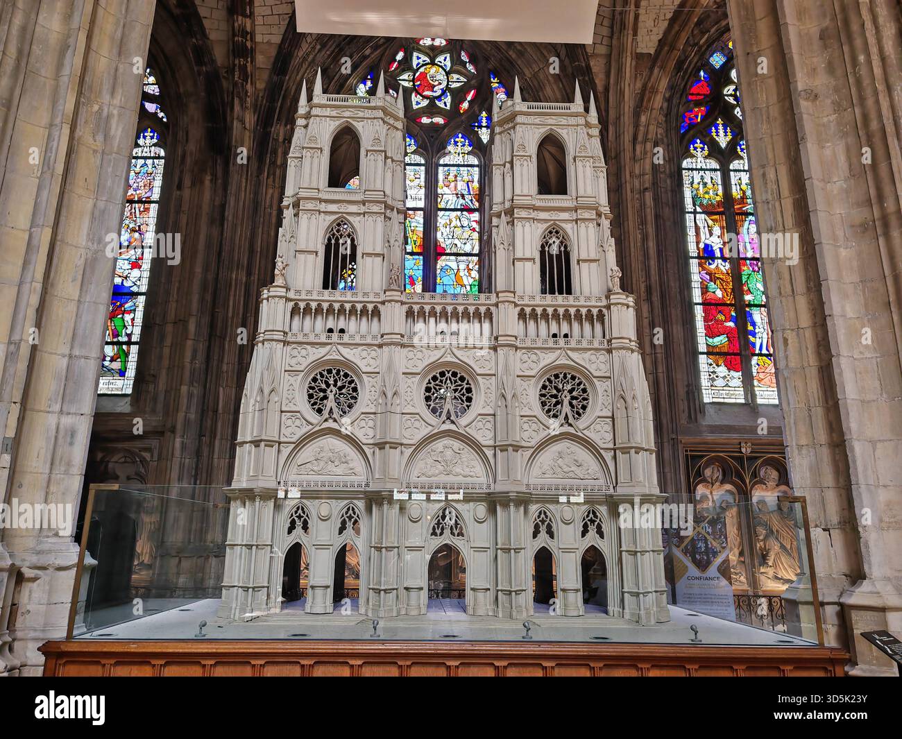 Miniature model of cathedral inside a gothic church with stained glass ...