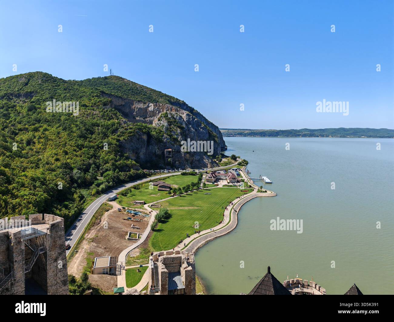 Aerial view of riverside promenade with green hill and calm water Stock ...