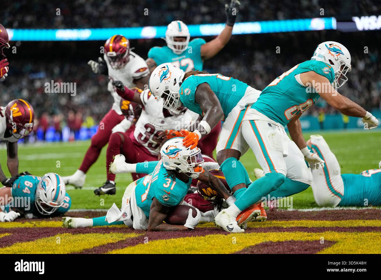 Miami Dolphins running back Ollie Gordon II (31), center, scores a ...