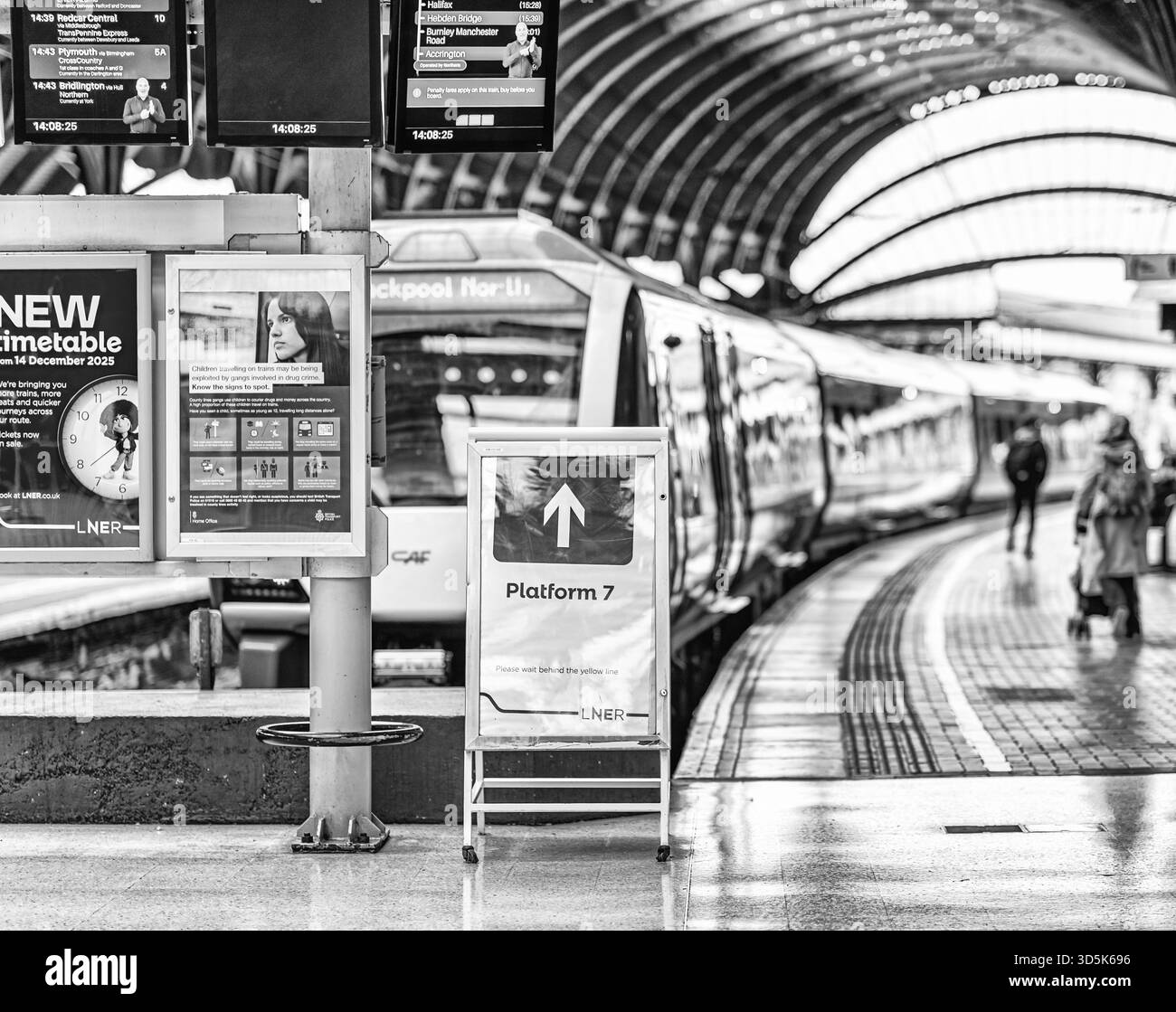 A railway station concourse with signs and information are in the ...