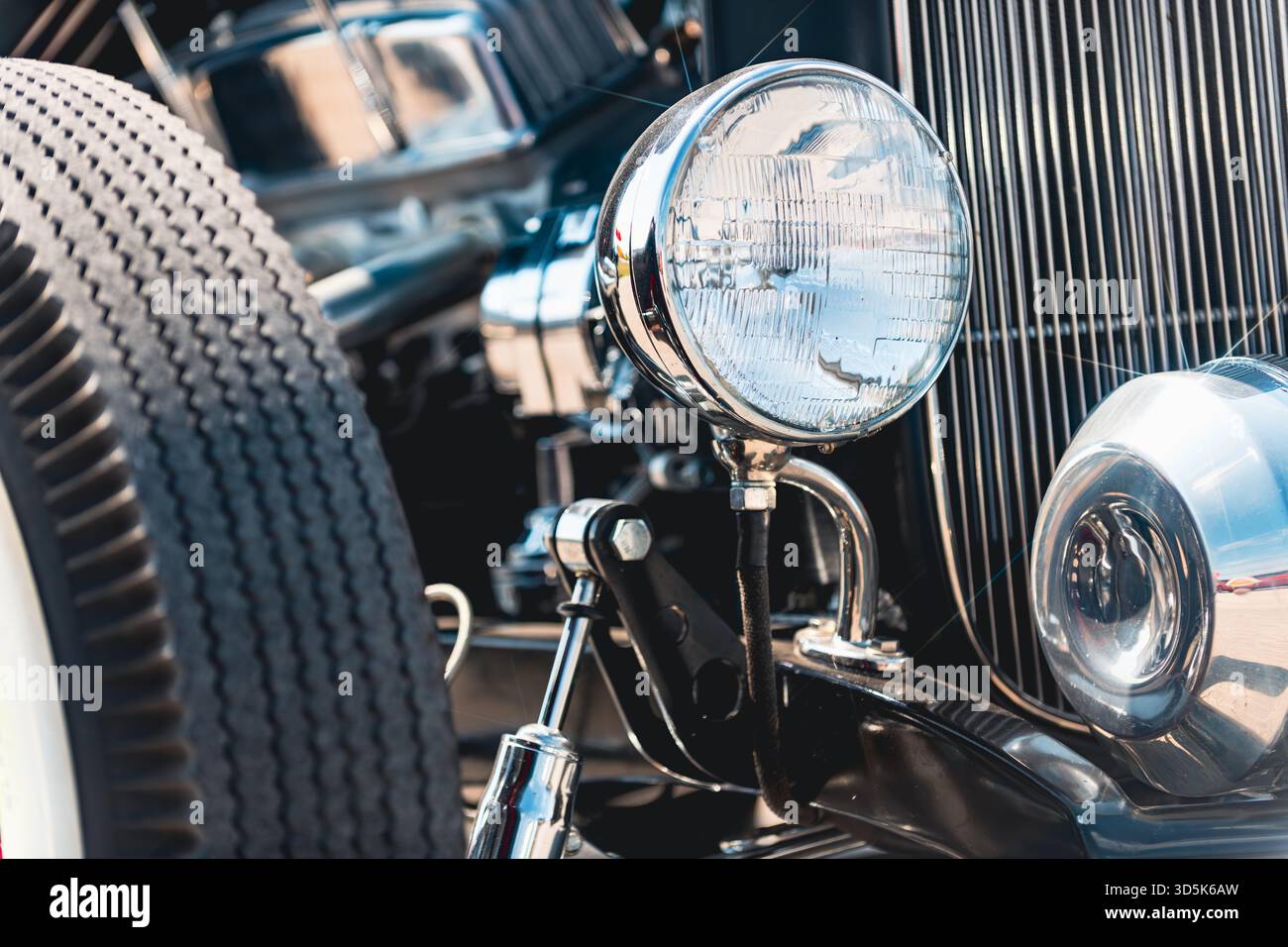Headlight on vintage hot rod with vertical grille bars and classic tire ...