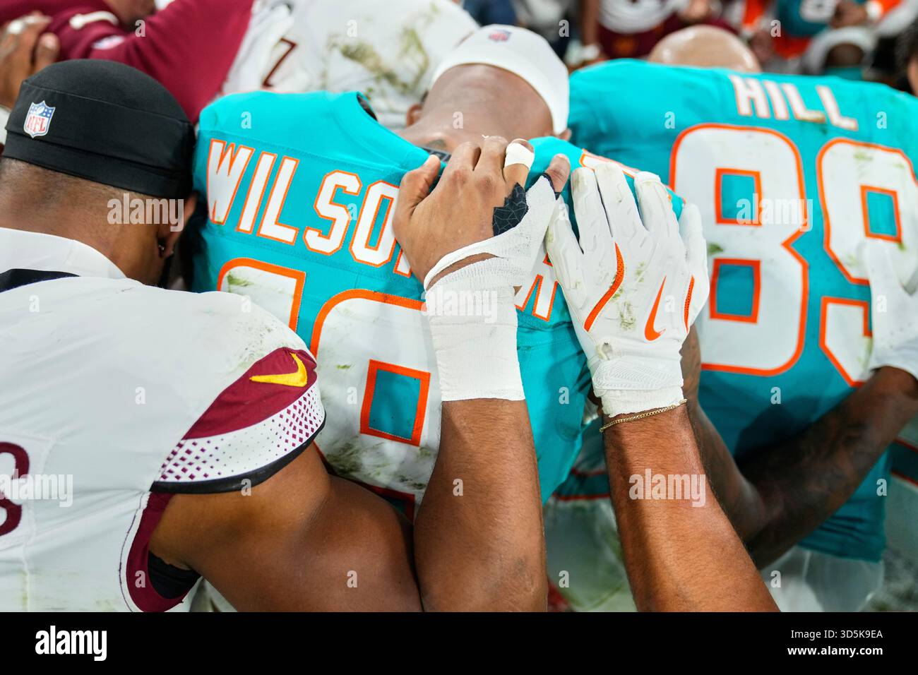 Players from both teams pray after an NFL football game between the ...