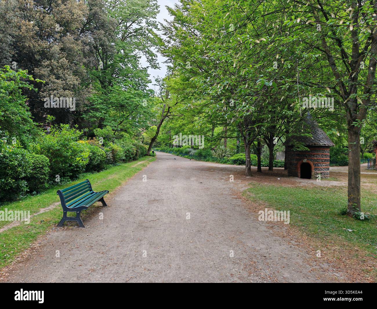 Park pathway with bench and small stone hut among trees Stock Photo - Alamy