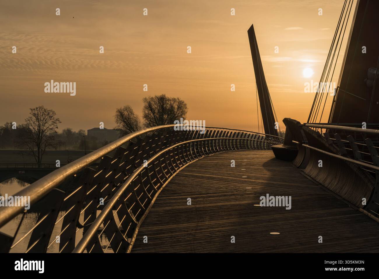 Modern curved pedestrian bridge with wooden deck and metal railings ...