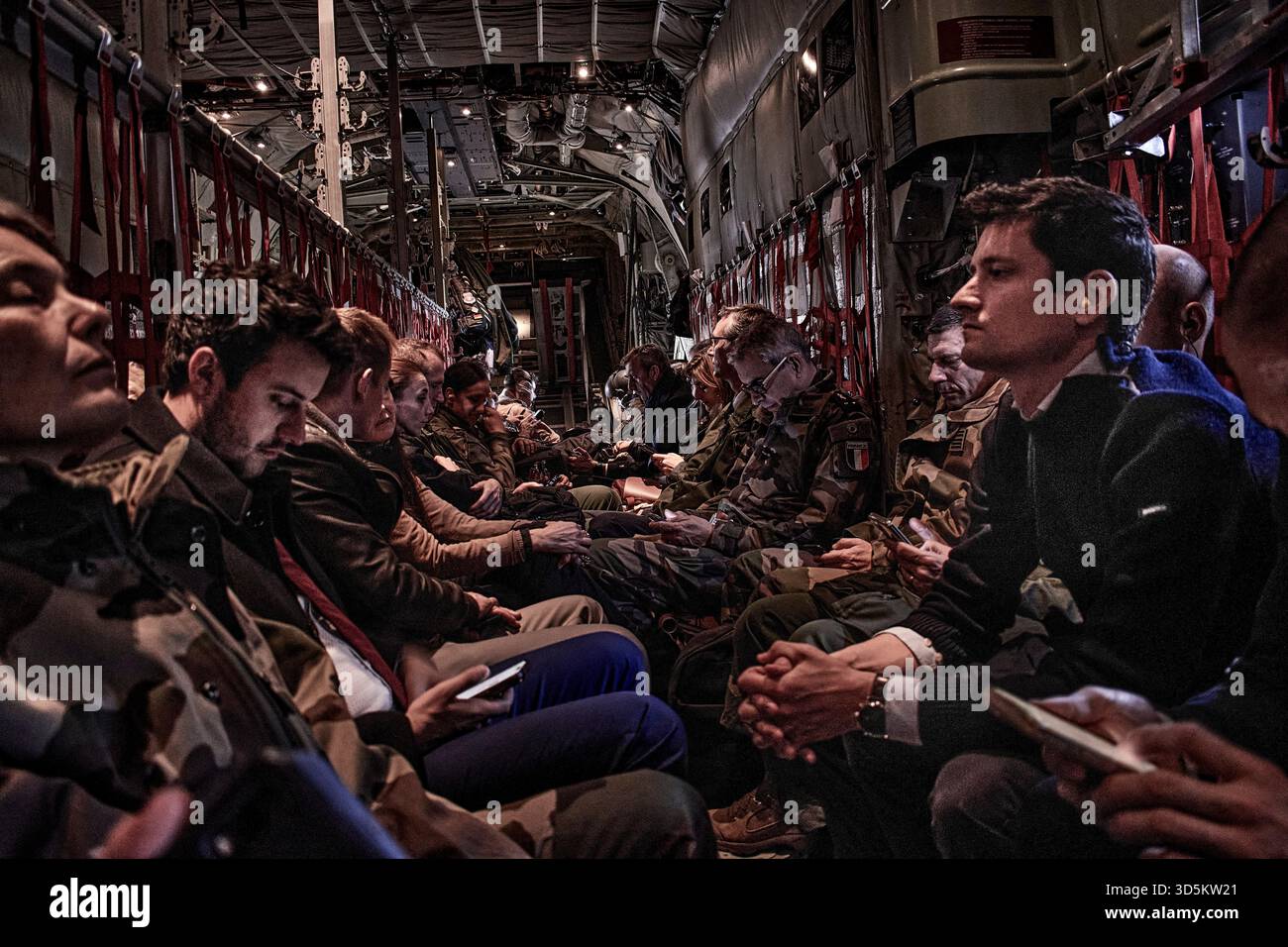 Military personnel and civilians onboard a C-130J transport aircraft ...