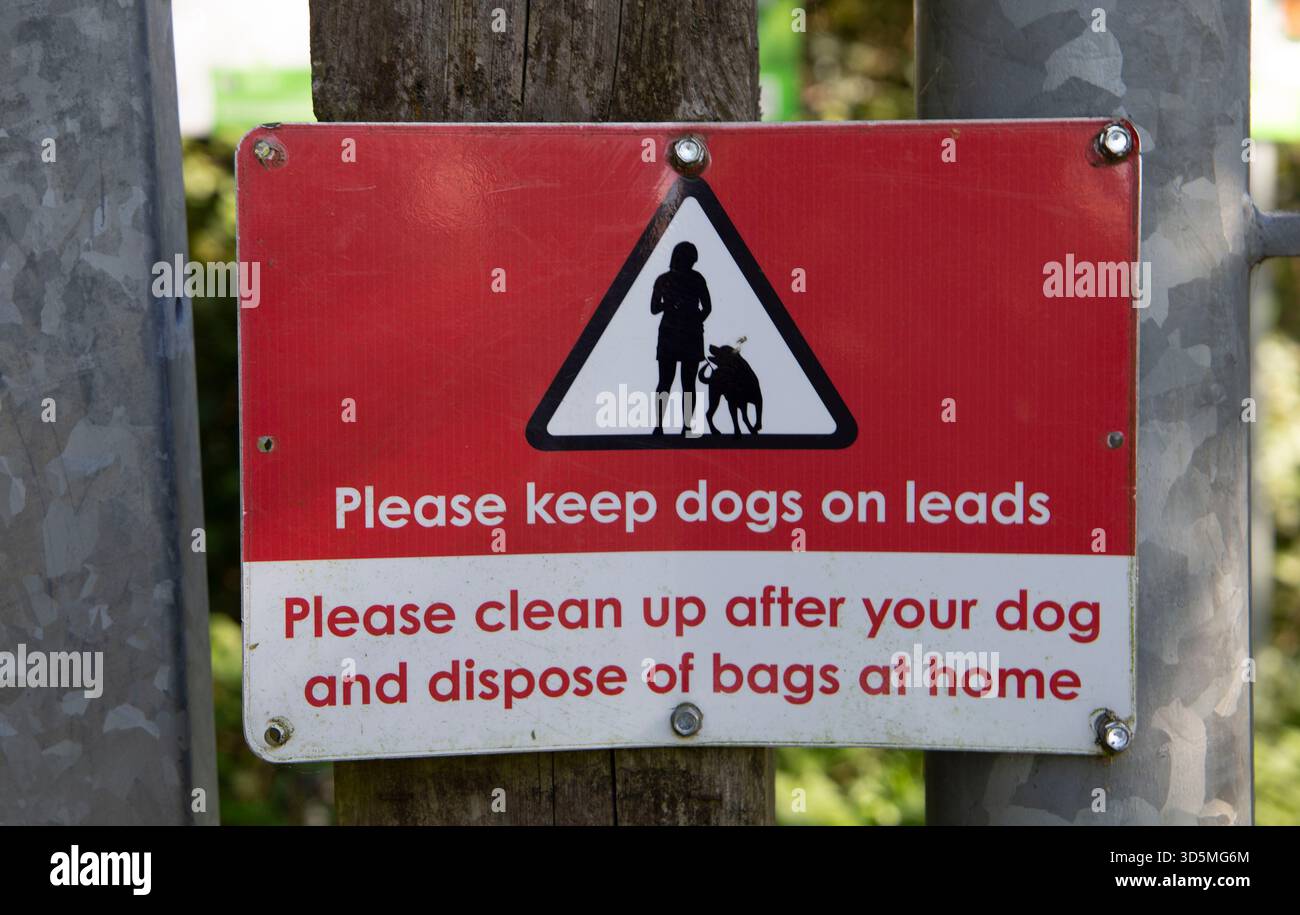 Red and white warning sign requesting dog owners to keep dogs on leads ...