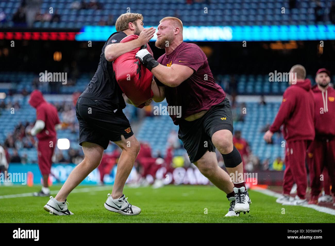 Washington Commanders center Tyler Biadasz (63), right, warms-up before ...