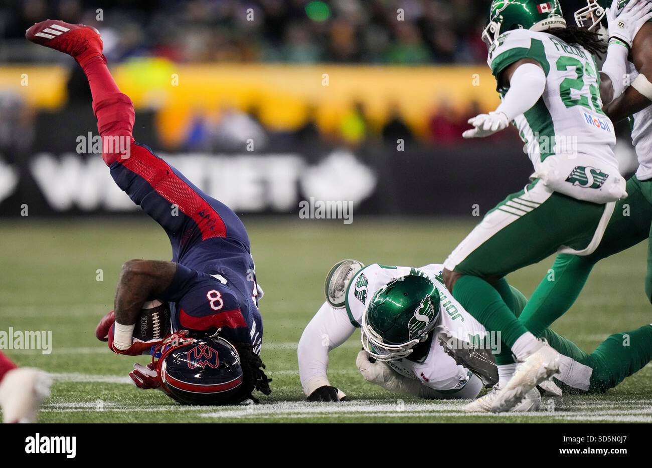 Montreal Alouettes' Stevie Scott III (8) is upended by Saskatchewan ...