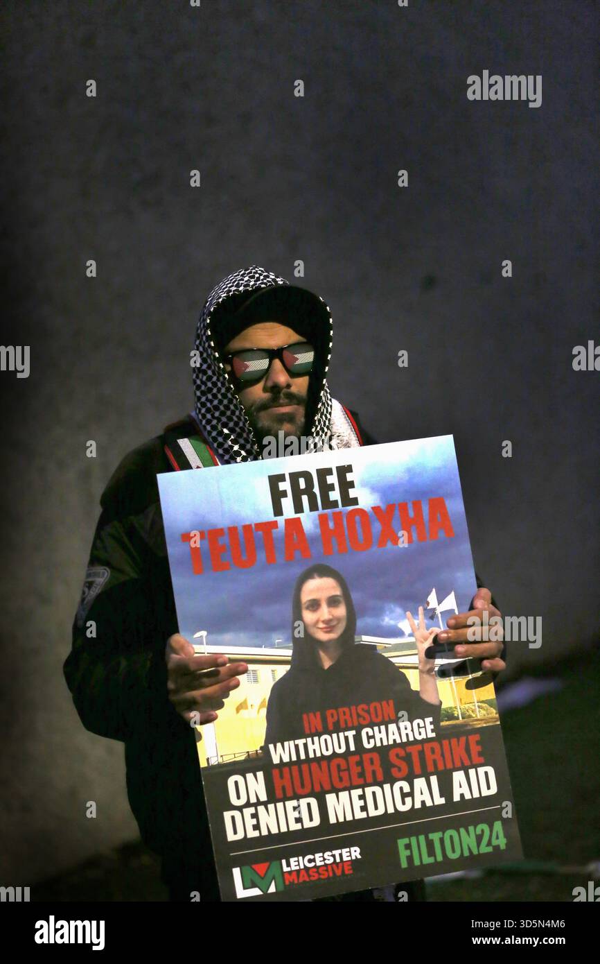 A protester holds a placard calling for hunger striker Teuta Hoxha to ...