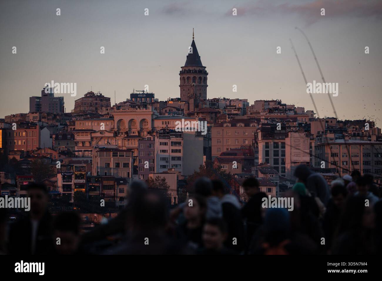 People fishing on the Galata Bridge at sunset in Istanbul, with the ...