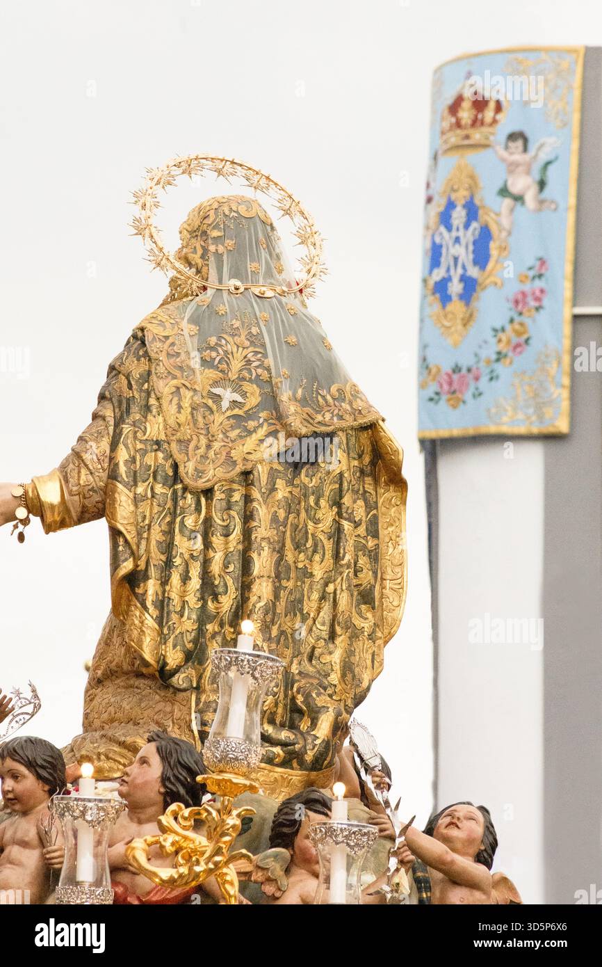 Virgin Mary seen from behind walking on her throne with a blue flag ...