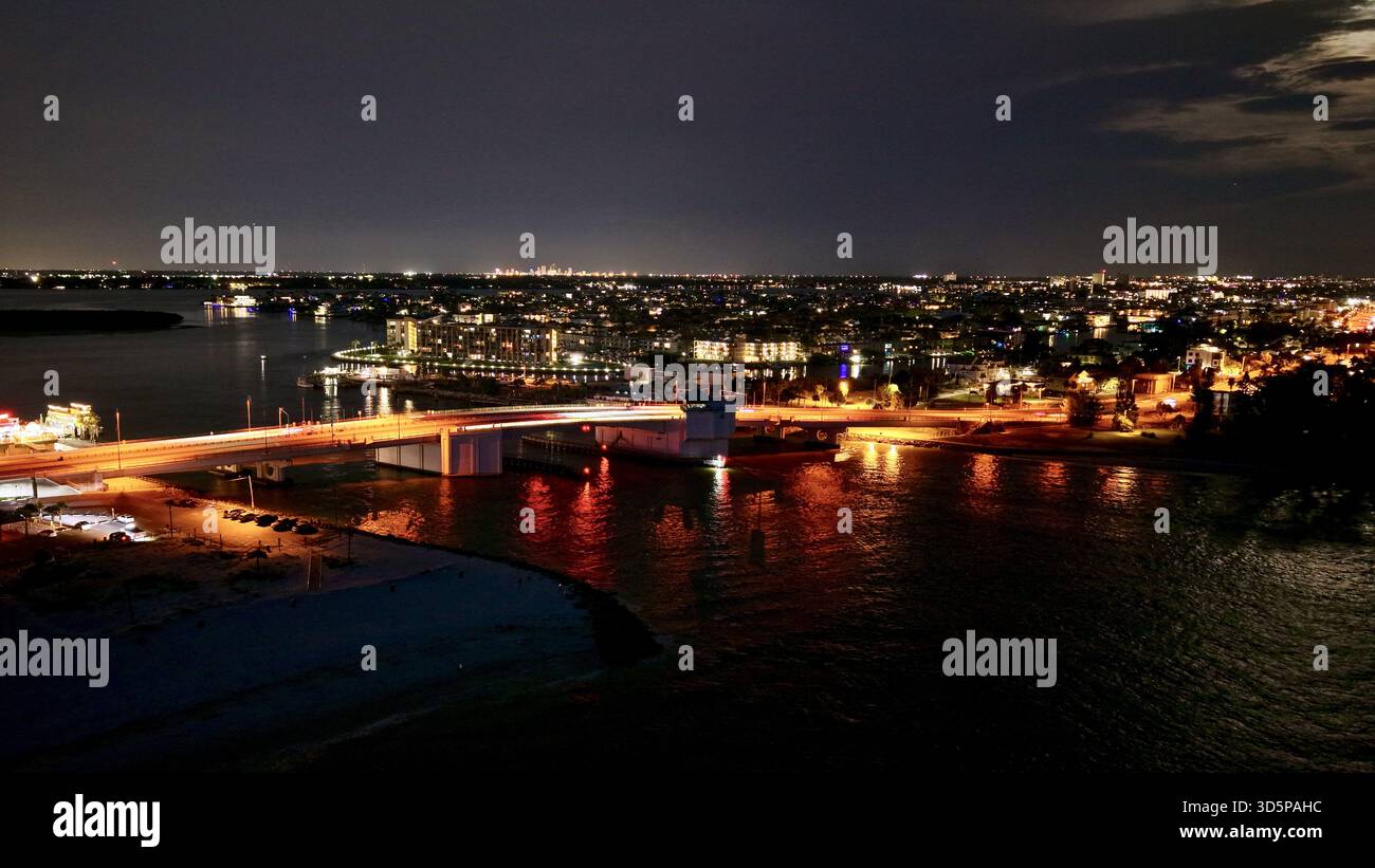 Aerial view of the bridge over the water, its lights reflecting in the ...