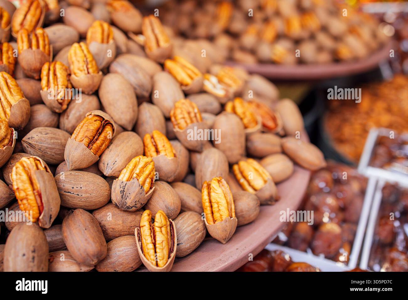 Fresh pecans in shells are beautifully arranged on a market table ...