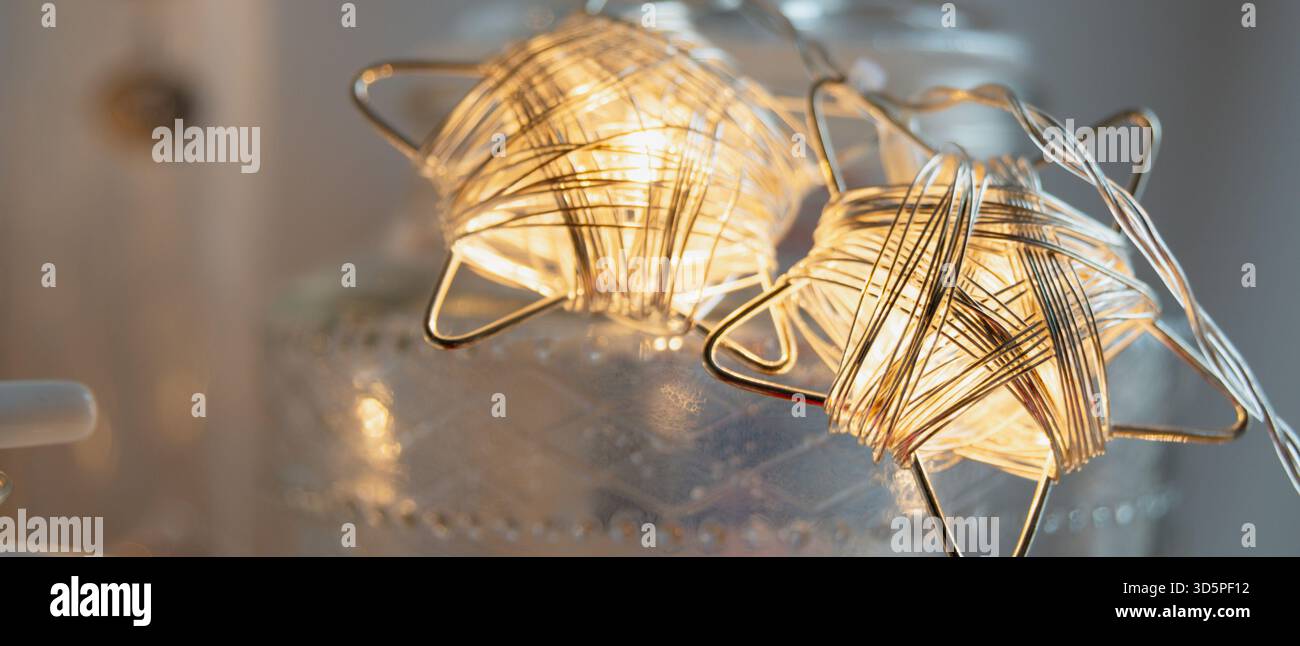 Warm light from a star-shaped wire garland, lit as decoration in an ...