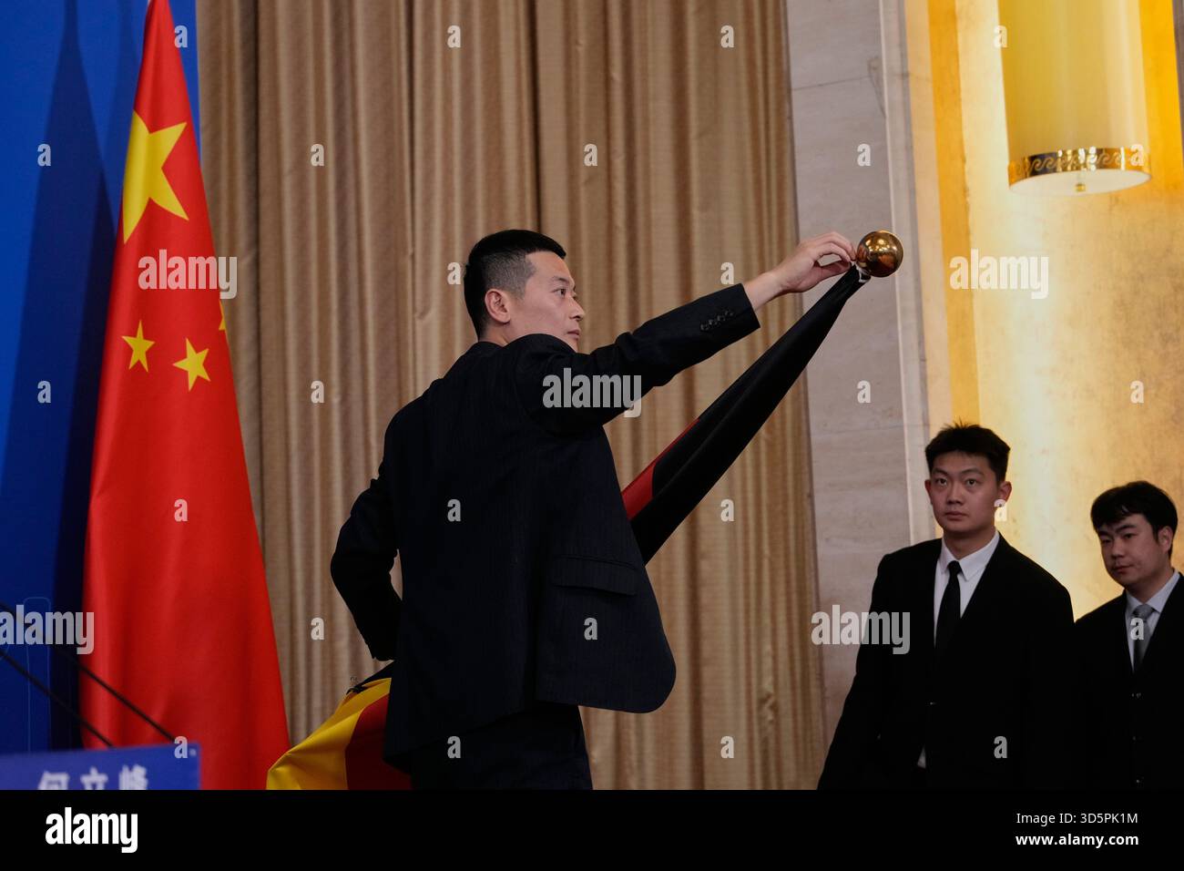 A worker prepares the flags for joint press conference by Chinese Vice ...