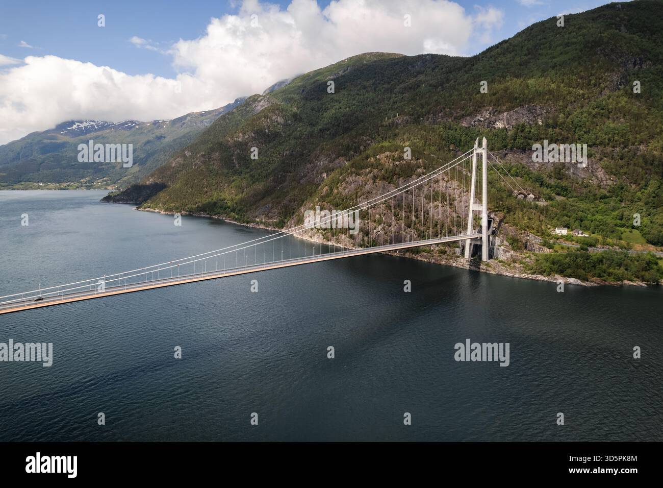 Aerial view of the Hardanger Bridge stretches across the dark waters of ...