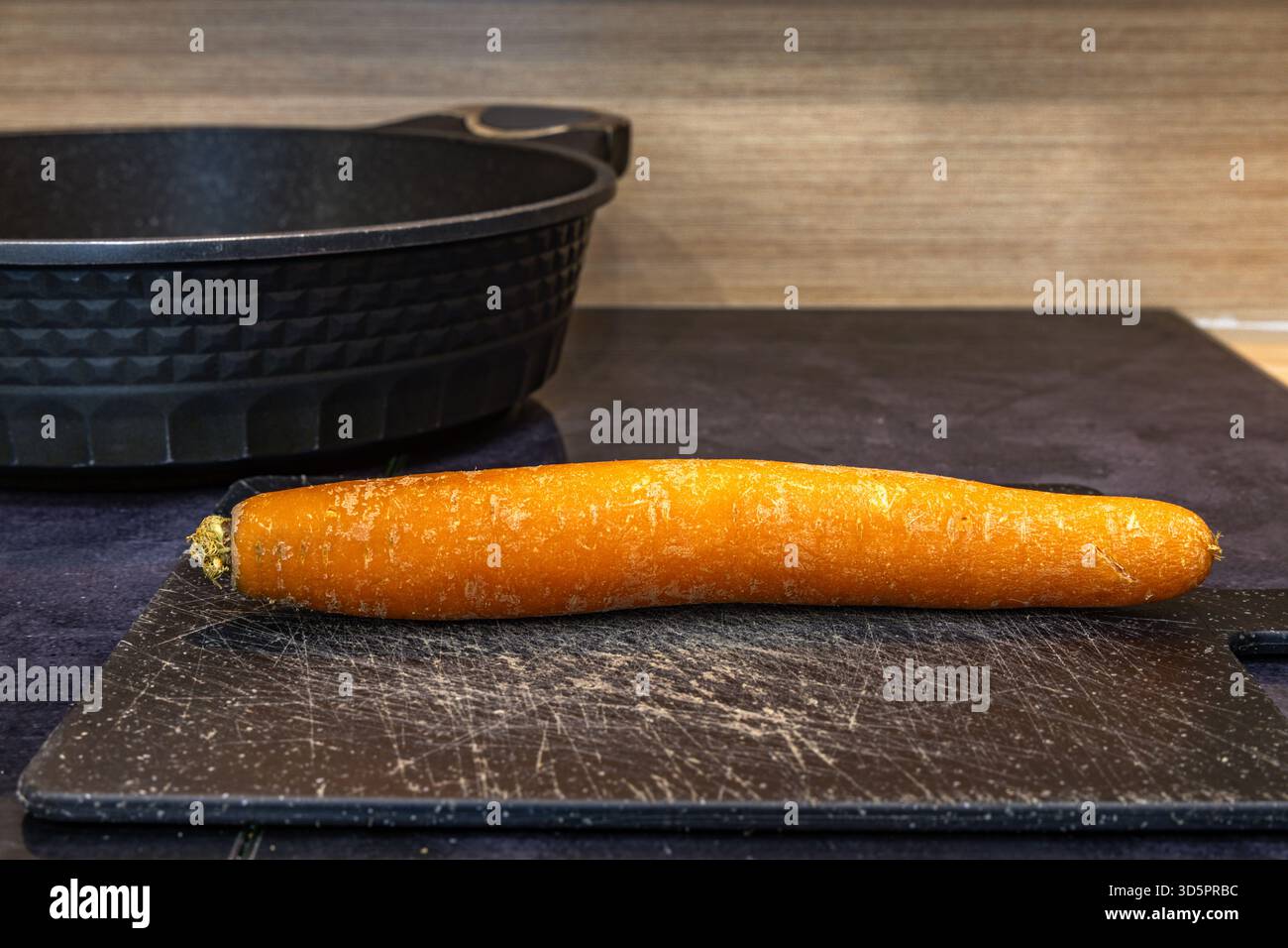 A carrot placed on a kitchen counter, preparing to cut carrots for a ...