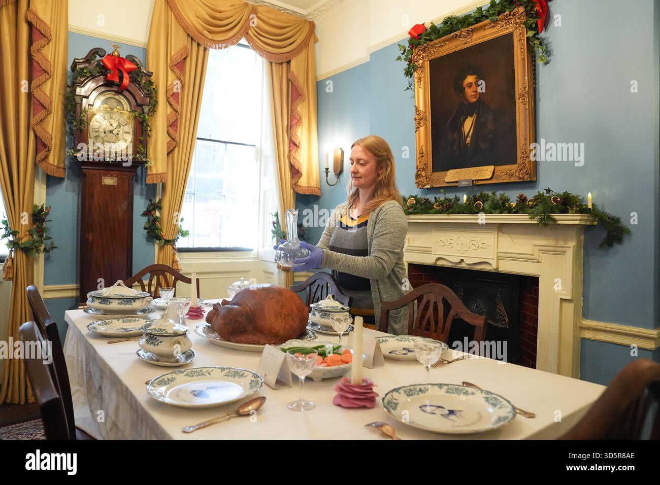 A member of staff poses glassware next to a table displaying a ...