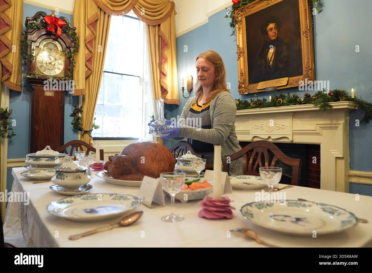 A member of staff poses glassware next to a table displaying a ...
