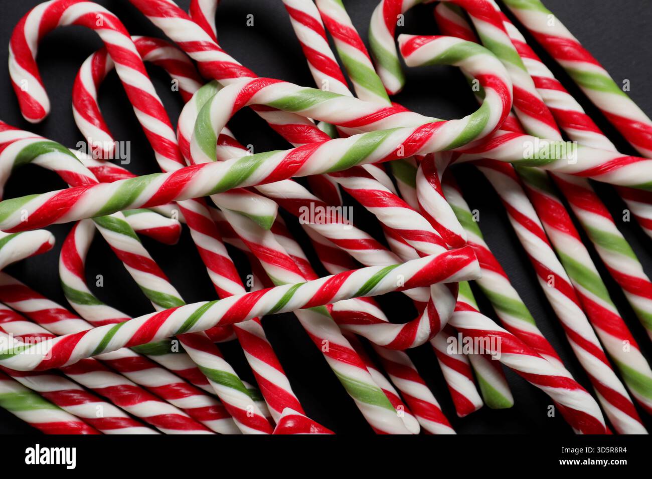 Tasty candy canes on black background, flat lay. Christmas treat Stock ...