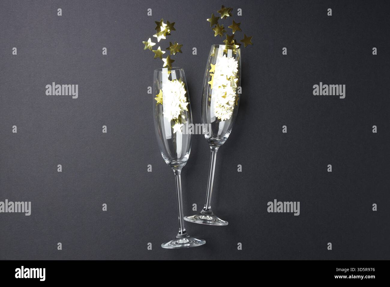 Merry Christmas and Happy New Year. Flute glasses with golden star ...