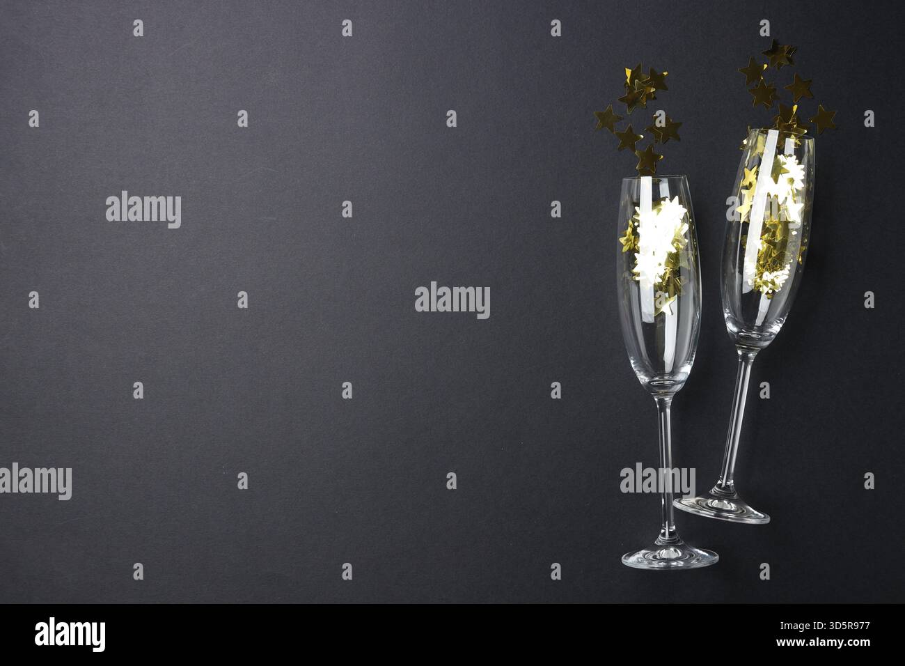 Merry Christmas and Happy New Year. Flute glasses with golden star ...