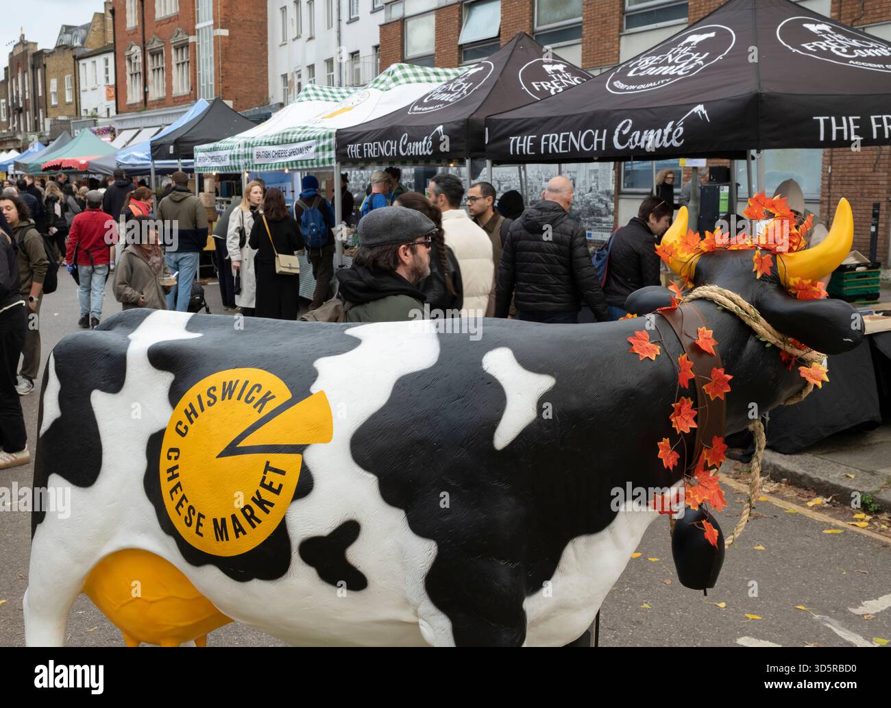 A large fake cow sporting a sign for the monthly Chiswick Cheese Market ...
