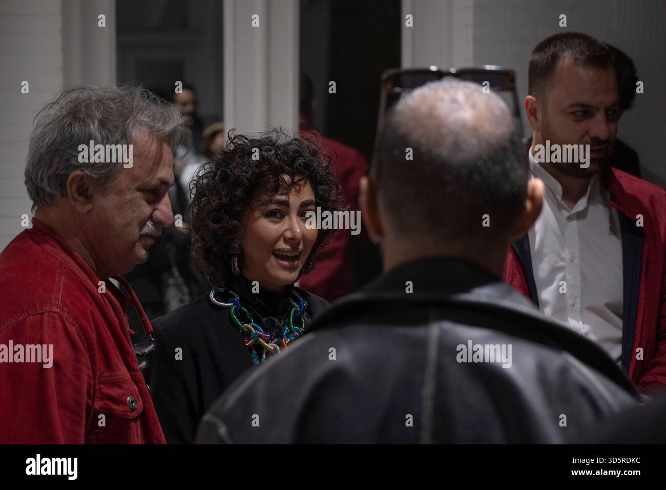 A young female Iranian fashion designer speaks with her audience as ...