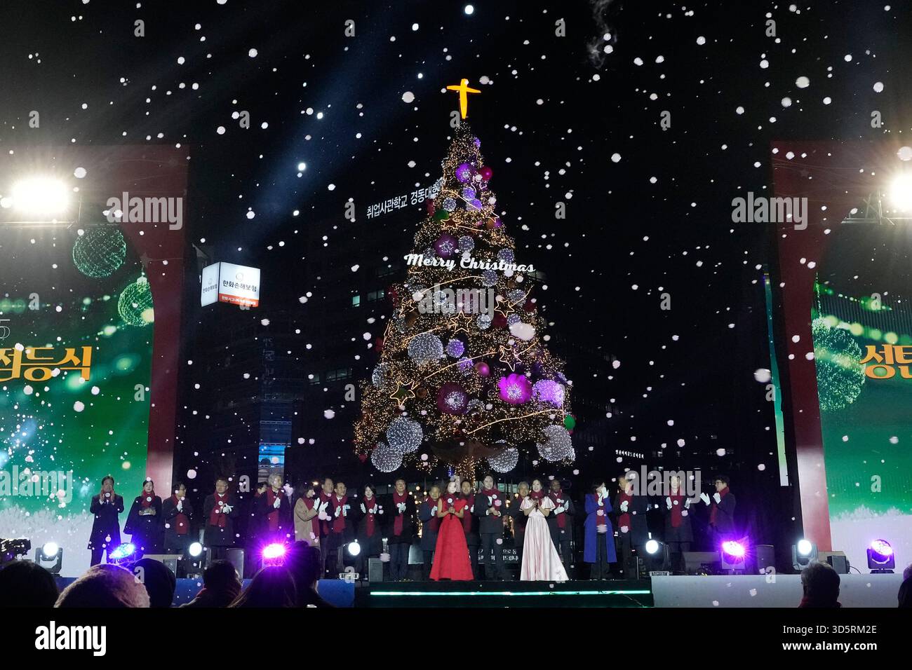 Attendees participate in a lighting ceremony of a Christmas tree to ...