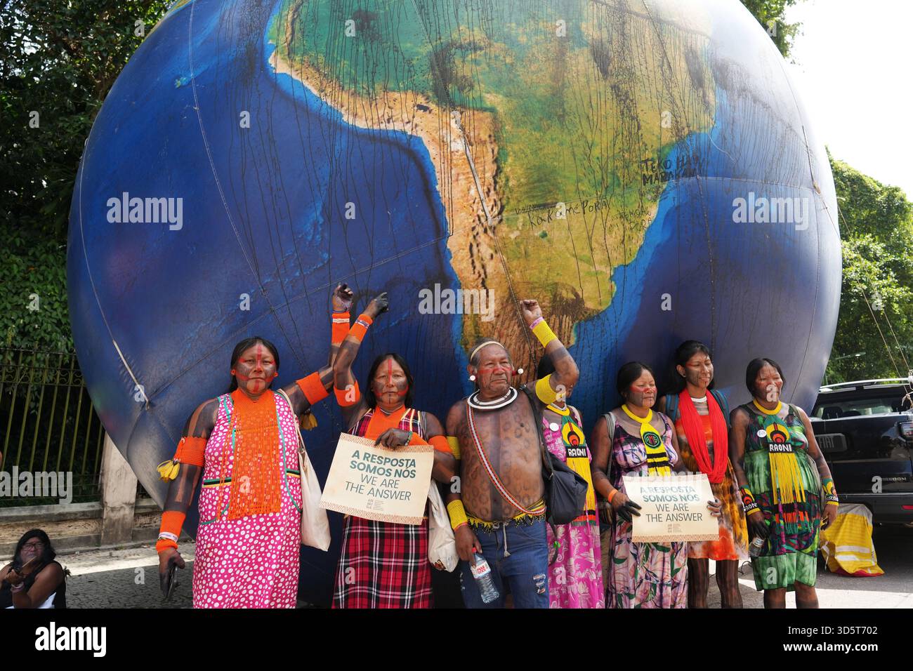 Indigenous activists pose for a photo in front of a globe at a climate ...