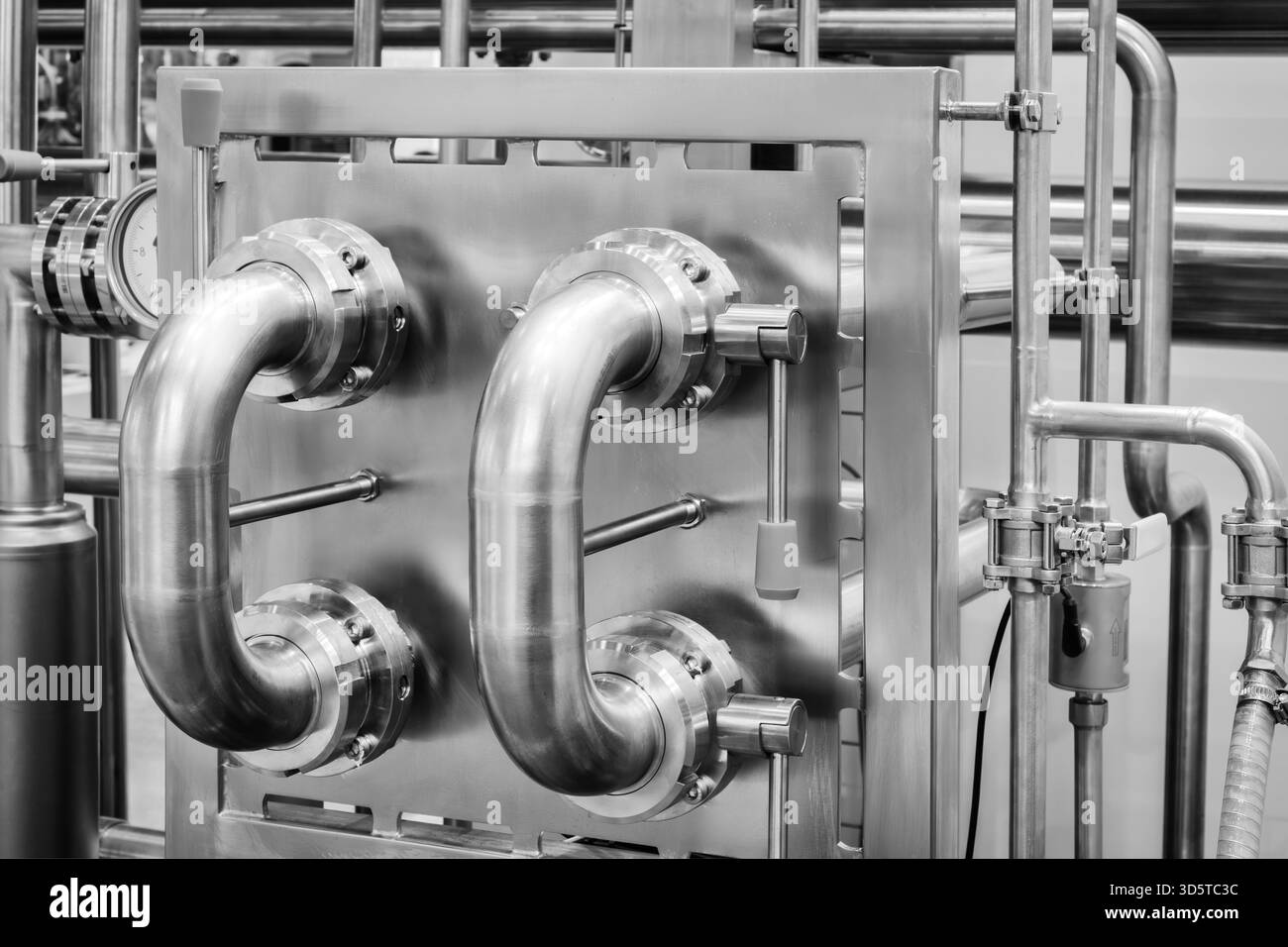 Stainless steel pipes attached to stainless steel tank with industrial ...