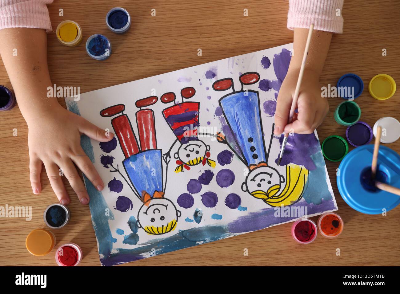 Little girl with brush drawing at wooden table, top view Stock Photo ...