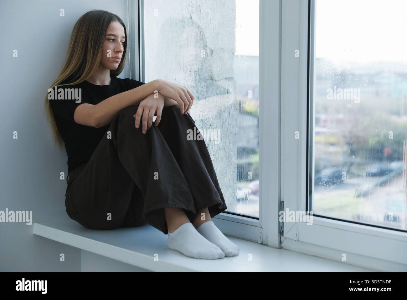 Depressed teenage girl near window at home Stock Photo - Alamy