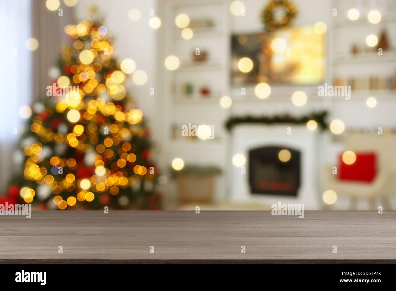 Empty wooden table against blurred room with Christmas tree, bokeh lights. Space for design ...