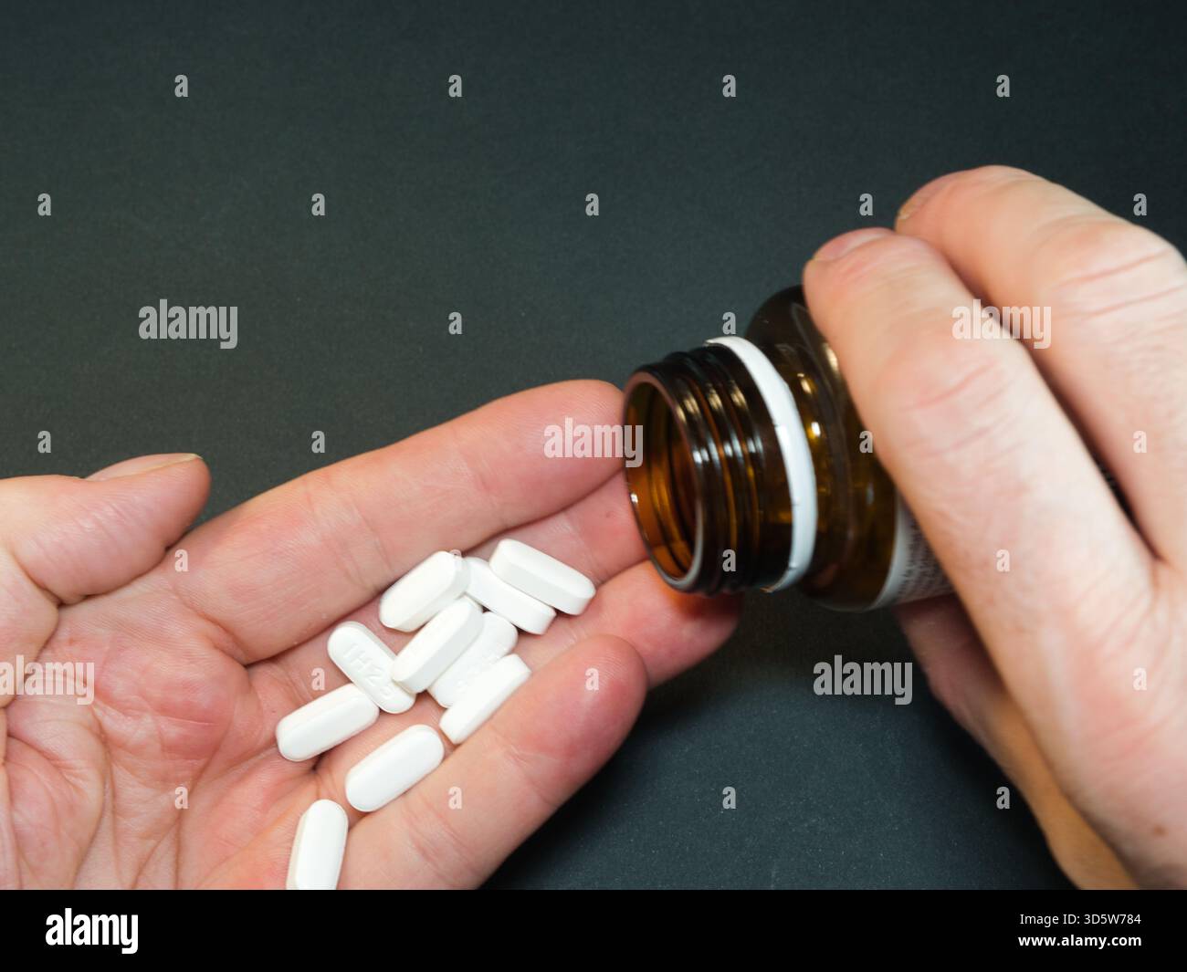 Hand Pouring White Pills from Bottle - Close-up of hands pouring white ...