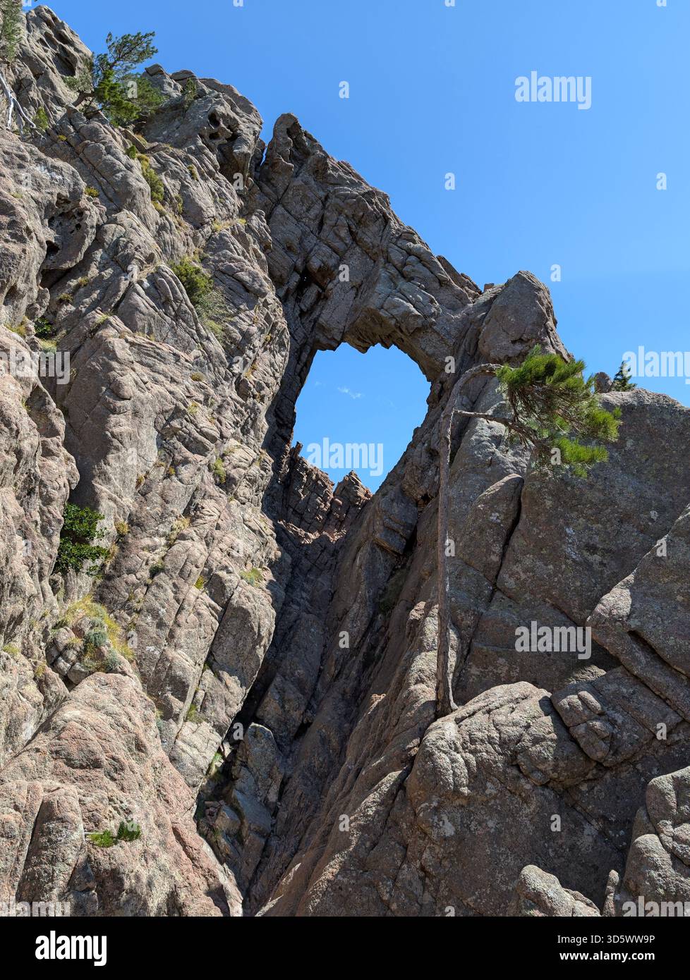 the bomb hole in the rock in the Bavella Mountains at sunshine und blue ...