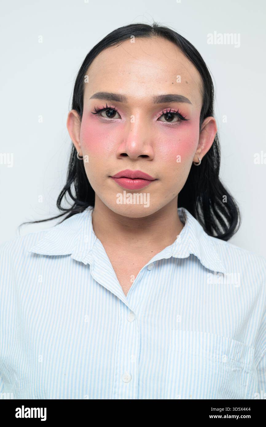 Studio portrait of a young Thai transgender individual with makeup and ...