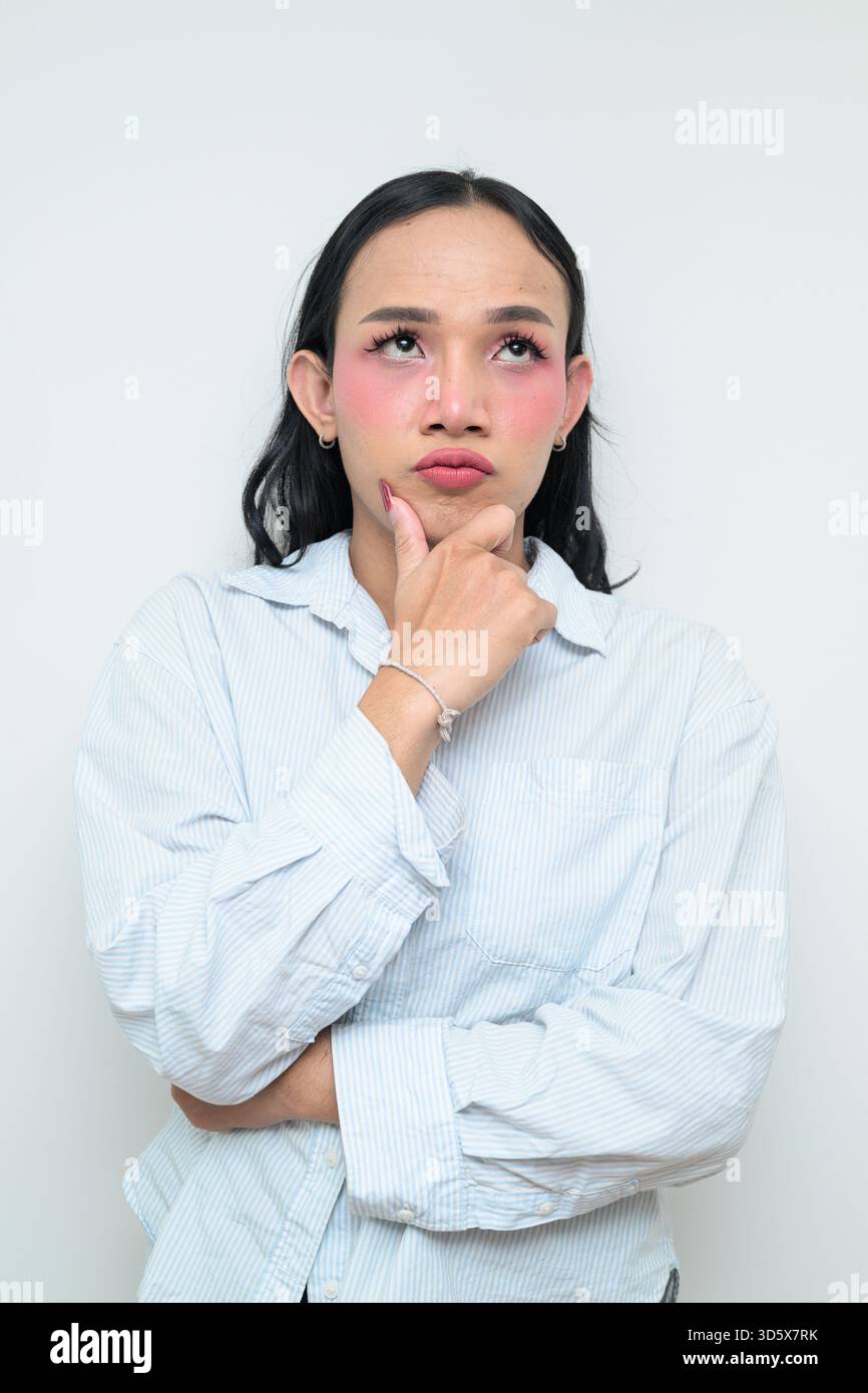 Studio portrait of a young Thai transgender individual with makeup and ...
