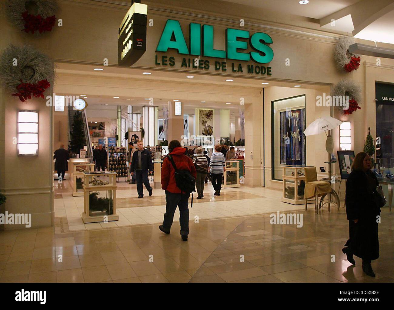 Shoppers walk by Les Ailes de la Mode fashion store in downtown ...