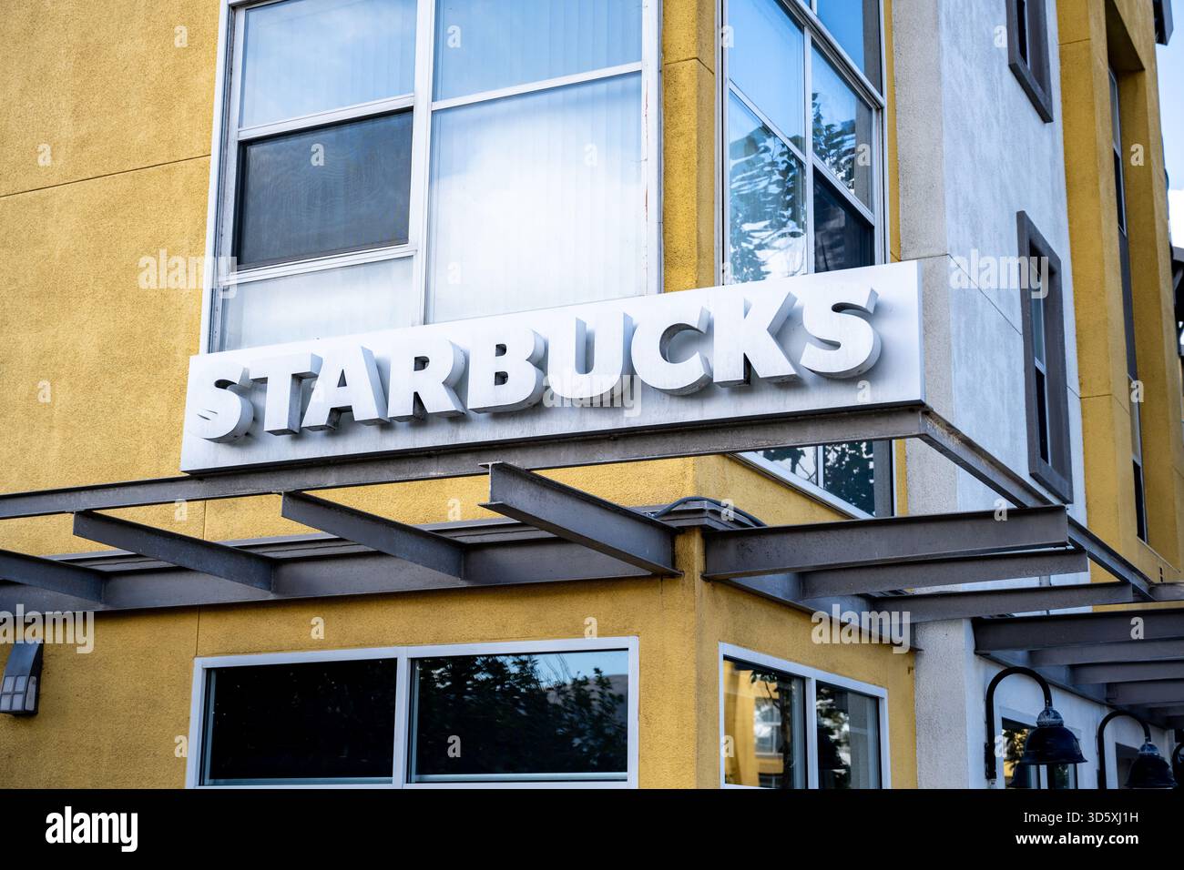 Starbucks storefront sign on yellow stucco building with metal awning ...