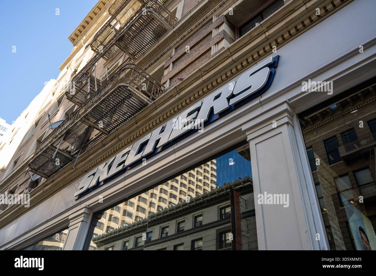 Skechers retail storefront with brand logo beneath fire escapes on ...